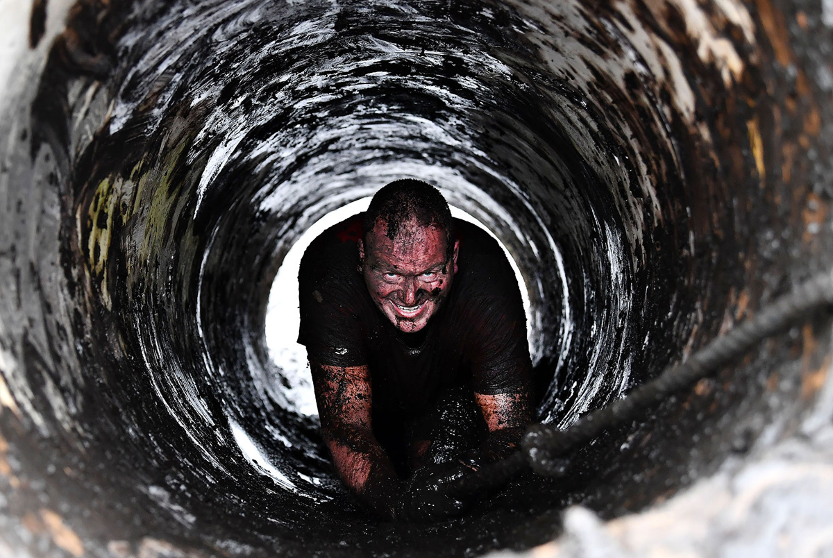 Solve A competitor makes his way up a manhole as part of the annual ...