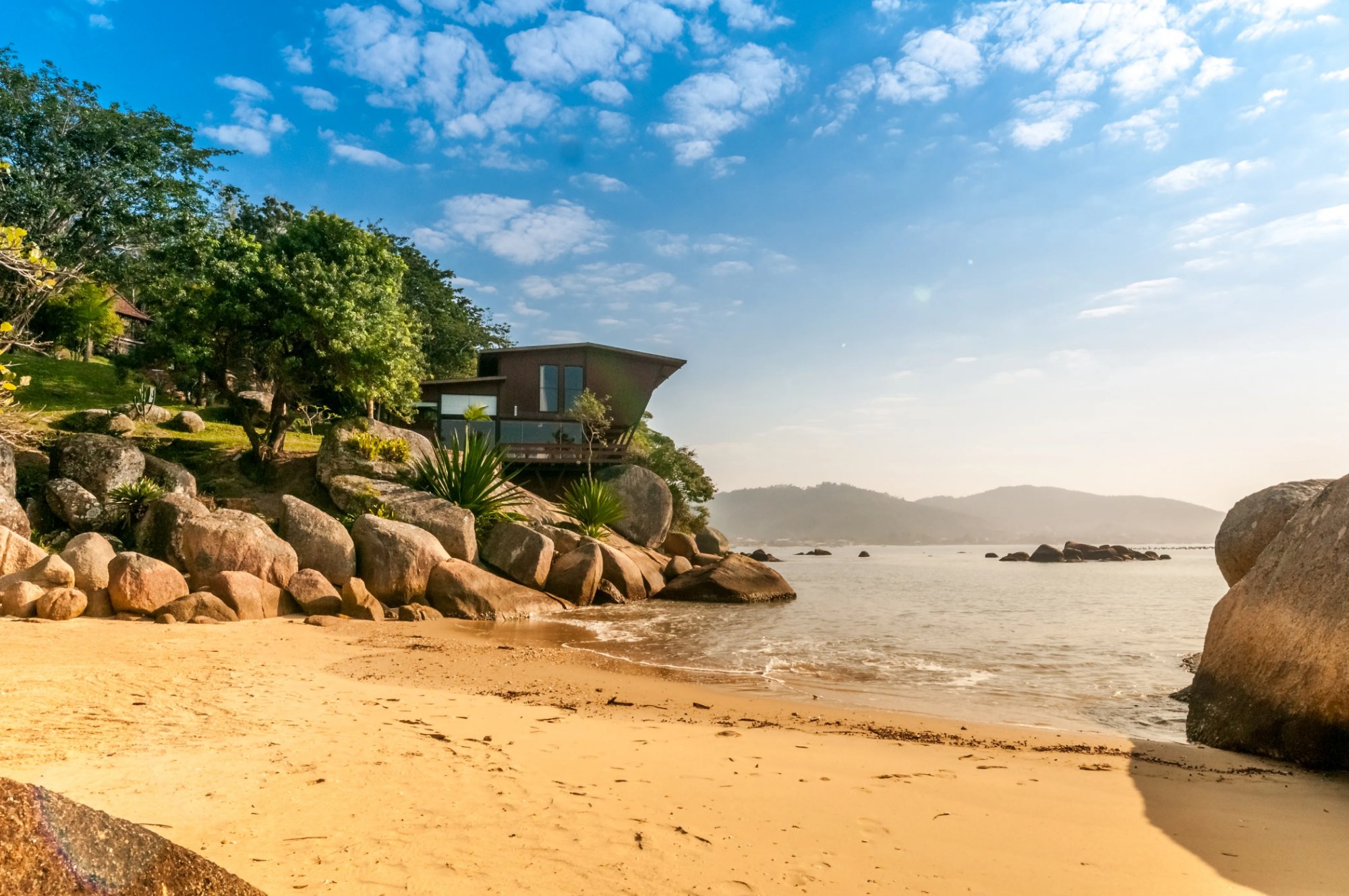 Solve Beachfront house, rocks and lush vegetation, common features on ...